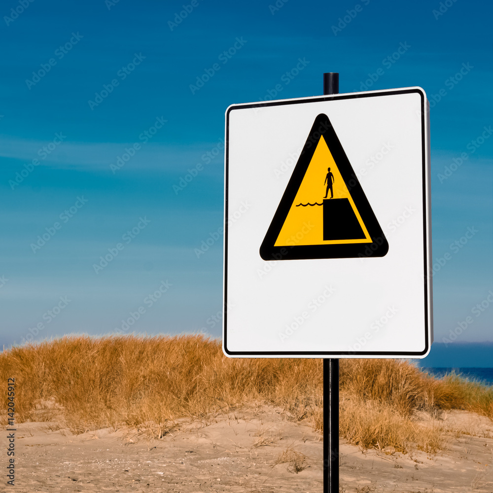 Foto Stock Yellow warning sign on summer beach, Riga | Adobe Stock