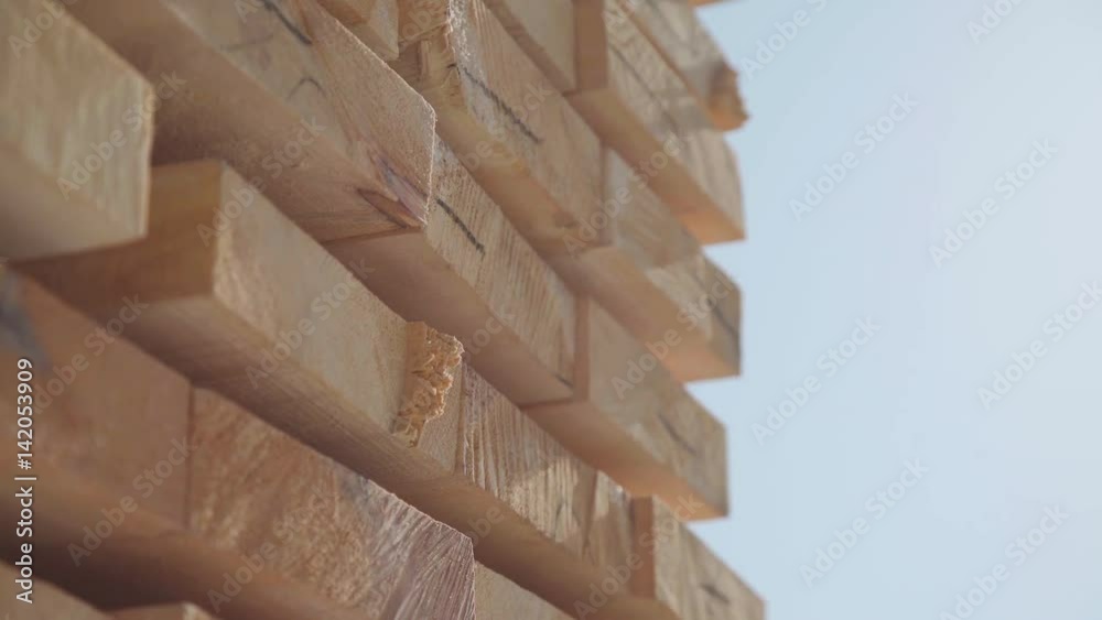 Vidéo Stock Wooden beams and boards neatly stacked in a pyramid shape ...