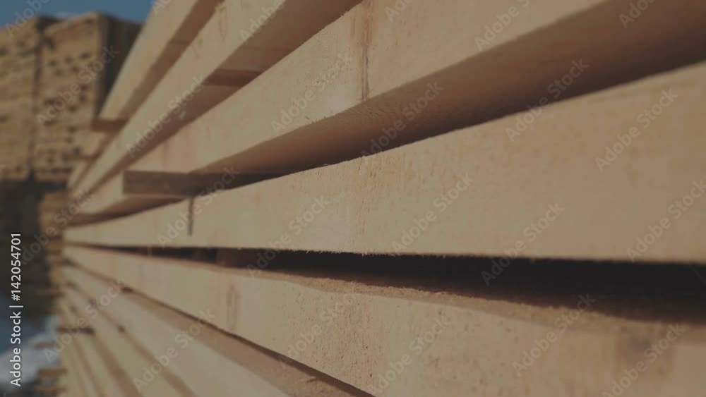 Wooden beams and boards neatly stacked in a pyramid shape. Wood ...