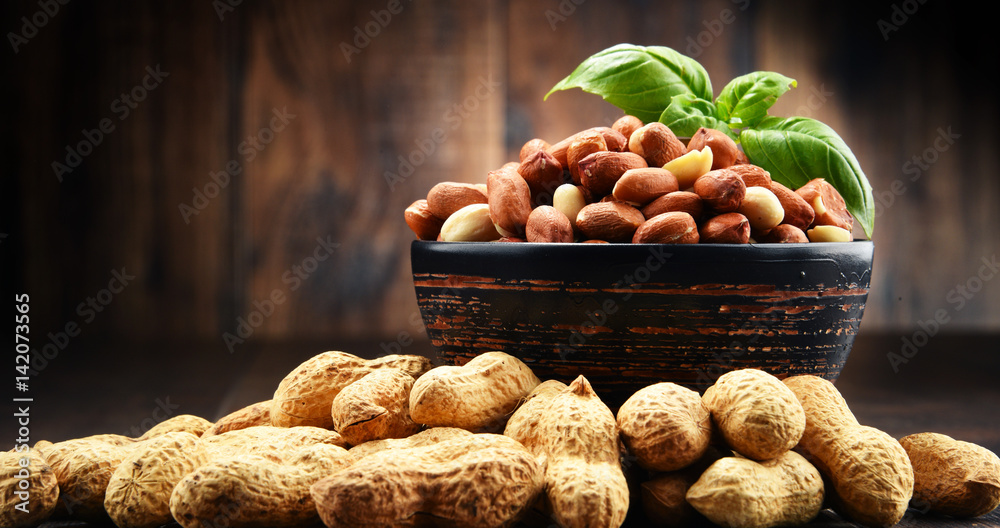 Bowl with peanuts on wooden table. Stock Photo | Adobe Stock