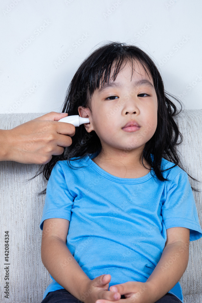 Asian Chinese little girl getting ear measurement for fever temperature ...