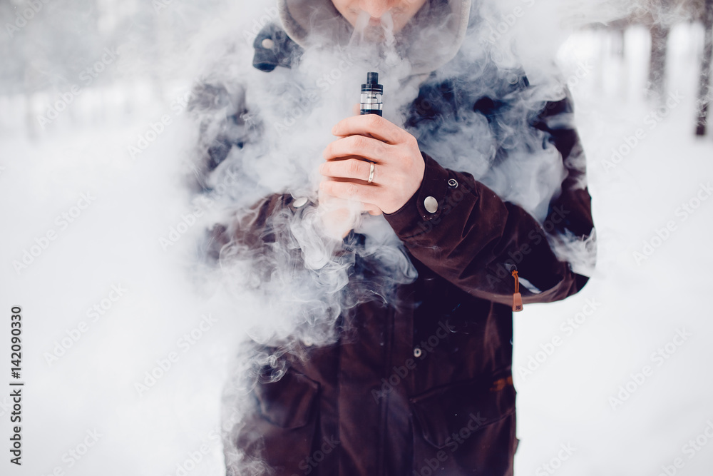 vaping man holding a mod device. cloud of vapor. Vape Stock Photo ...