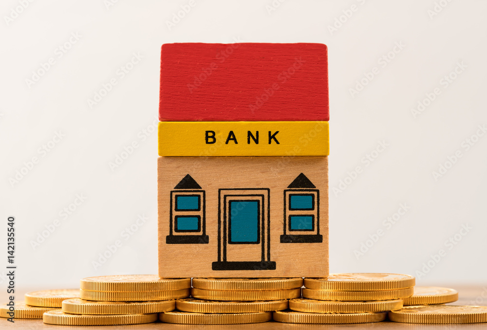 Toy bank building on gold coin assets Stock Photo | Adobe Stock