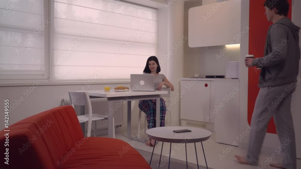 Woman sitting at the table watch funny video using computer. Man ...