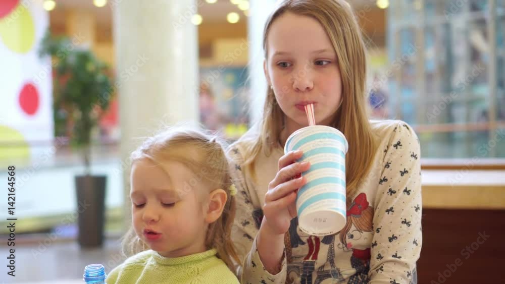 Cute little kid girls portrait funny eating in fast food court in a ...