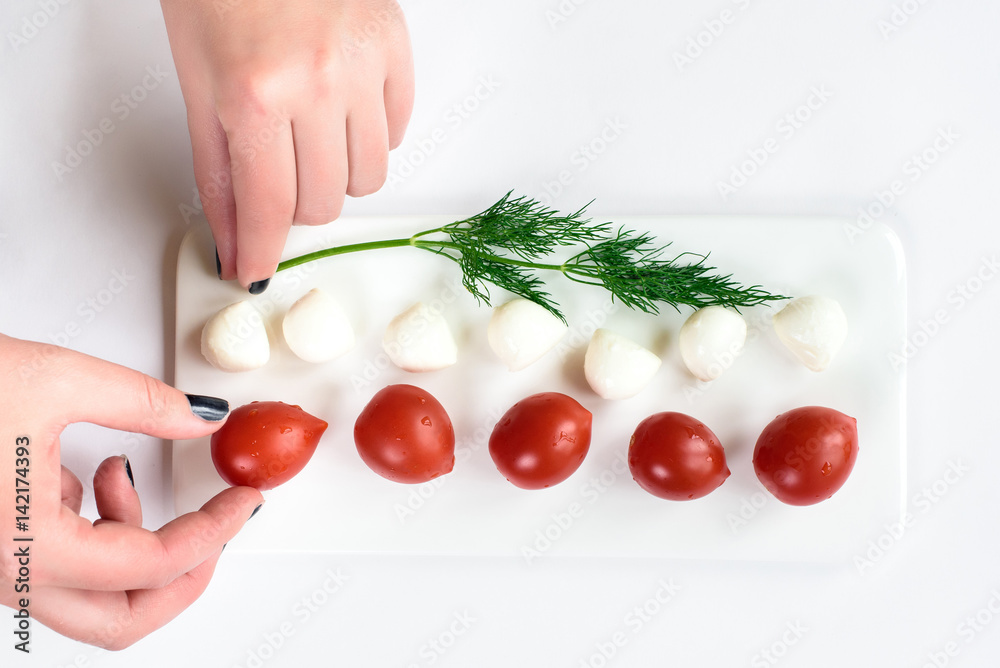 Gentle female hands fixing a composition of an upper view on a tomato ...