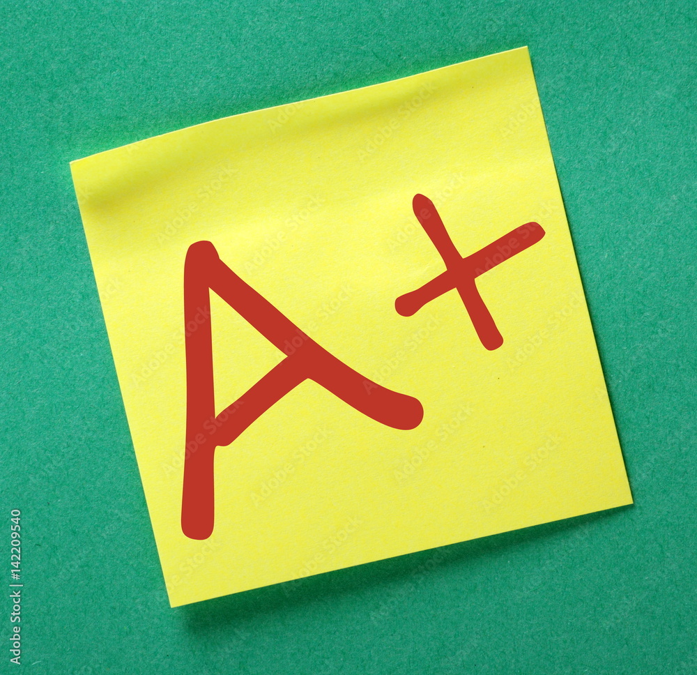 A Plus grade for your work in red text on a yellow sticky note posted ...