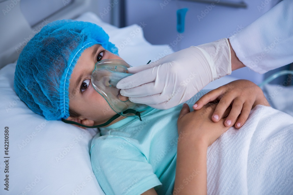 Doctor placing an oxygen mask on patient in ward Stock Photo | Adobe Stock