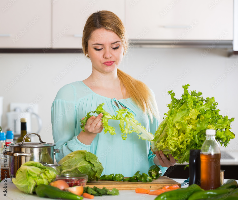 Young housewife tired of cooking vegetables in domestic kitchen Stock ...