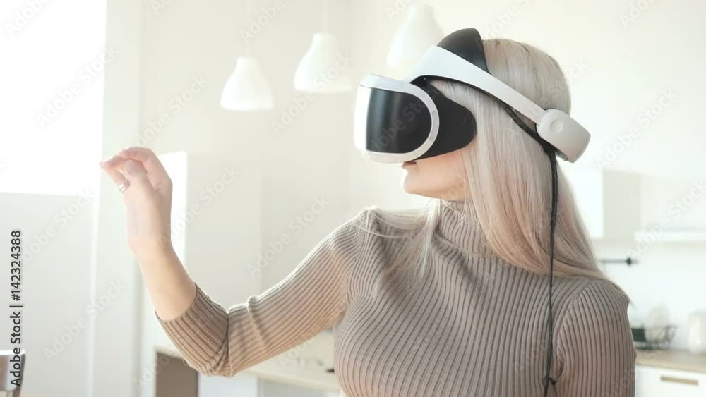 Future is right now. Young woman using 3D virtual reality headset ...