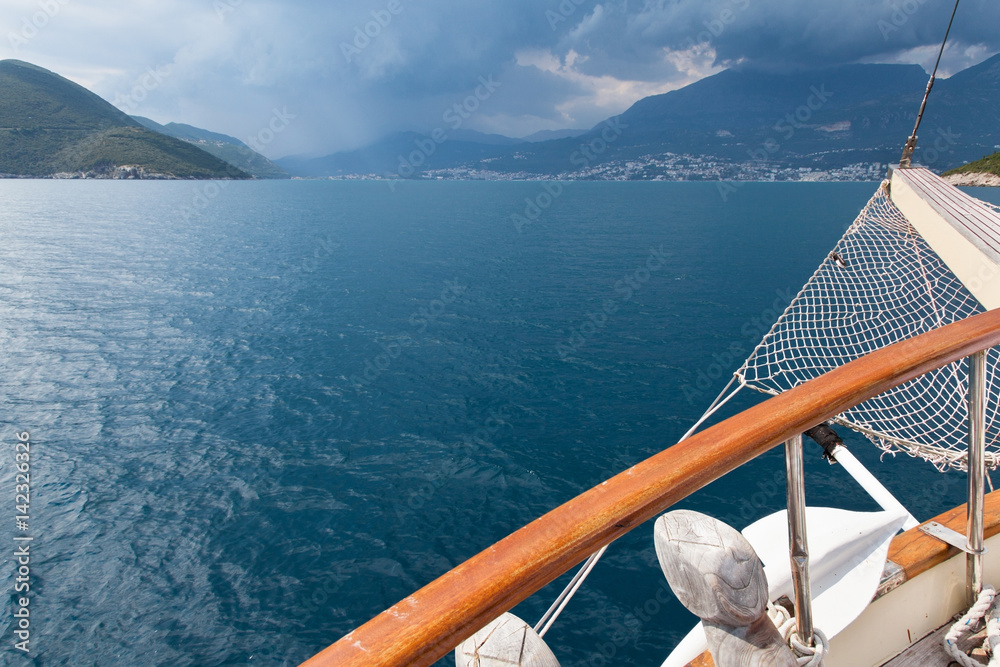 Sailing on yacht with amazing background of sea, mountains, cloudy sky ...