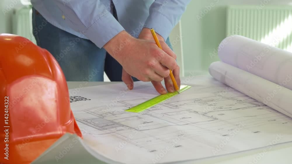 Young architect drawing lines on the design project. Close up of male ...