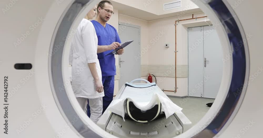 4K A doctor and a nurse invite the patient to be examined on an MR scan ...