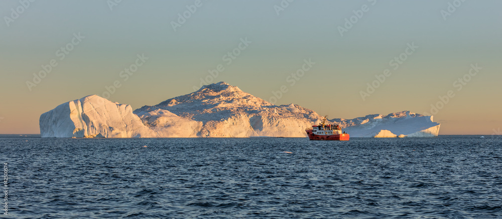 Tourists take pictures of the iceberg. Source of icebergs is by the ...