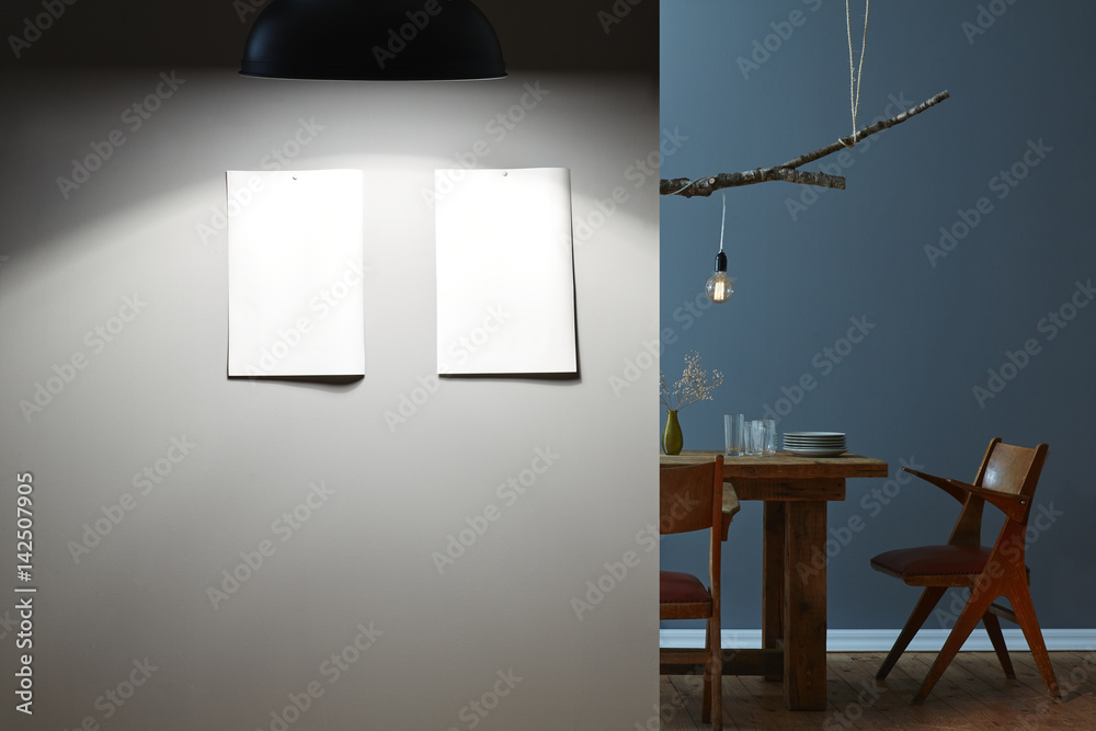 two rooms at night laid dinner table and posters on wall Stock Photo ...