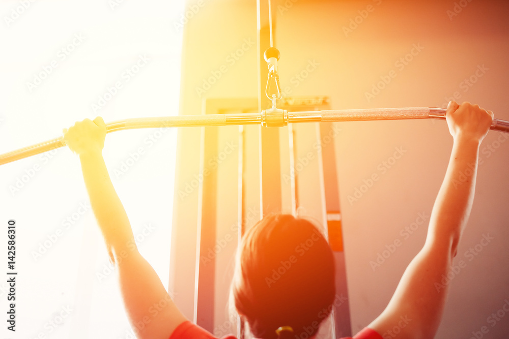 girl is doing an exercise on the widest muscles. in the gym. hands ... girl is doing an exercise on the widest muscles. in the gym. hands ...