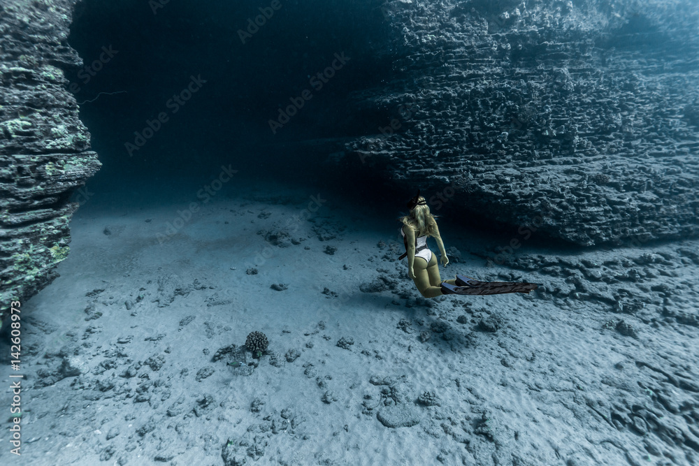 Female swimming underwater through cove Stock Photo | Adobe Stock