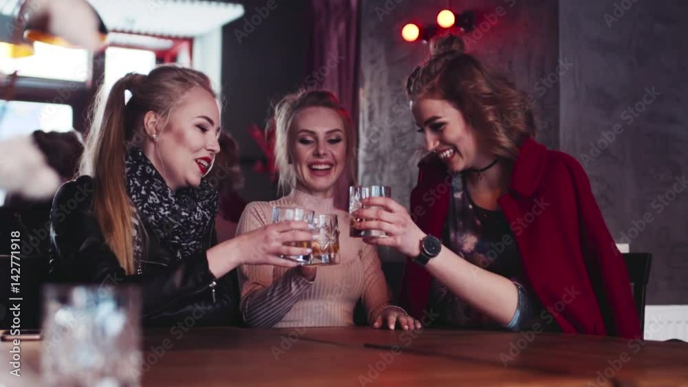 Three gorgeous women party hard with alcohol cocktails. Having fun with ...