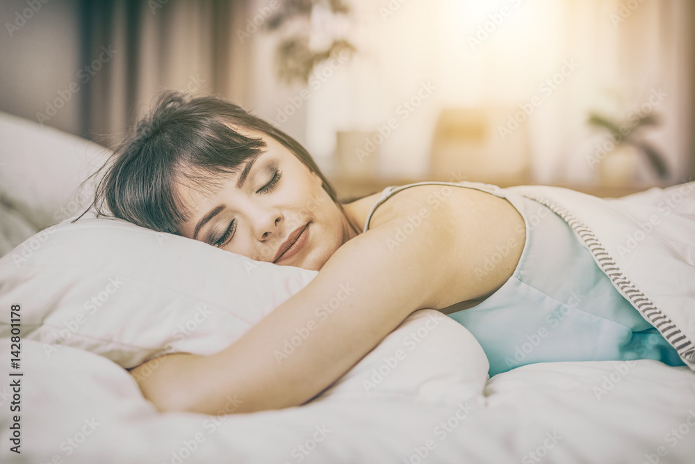 Beautiful young woman sleeping on a bed in the bedroom. Stock Photo ...