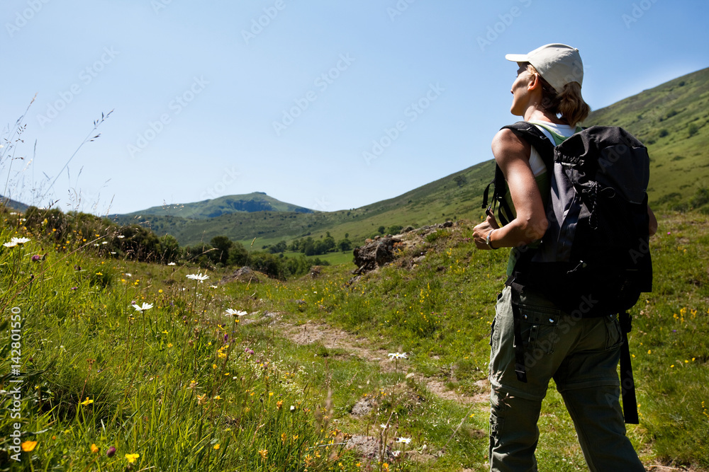 femme qui fait une randonnée dans la campagne avec son sac à dos en été ...