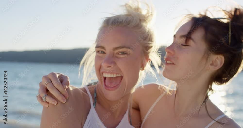 Beautiful young woman giving teenage girl friend kiss on cheek hugging ...