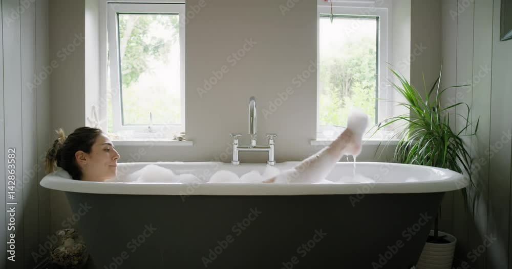 Vidéo Stock Beautiful Woman lying in bathtub enjoying relaxing bubble ...