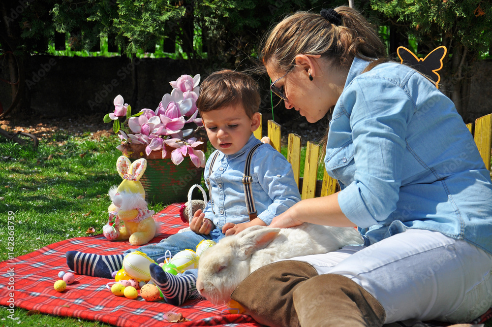 Little boy and his mother celebrate Easter on the meadow and playing ...