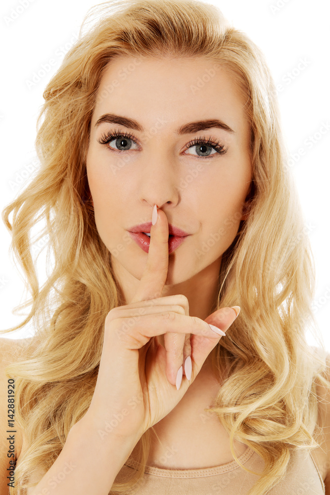 Beautiful woman with finger on lips Stock Photo | Adobe Stock
