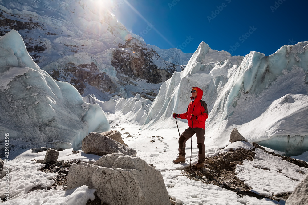 Trekkes is posing at camera in front of huge glacier falling from ...