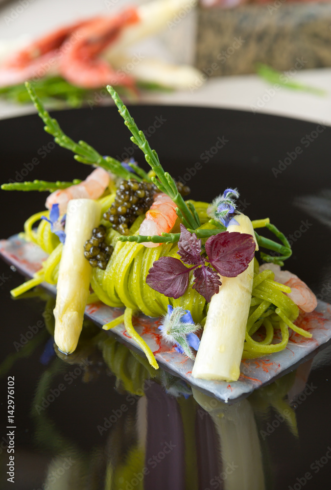 Watercress tagliolini, on a bed of red shrimp carpaccio. Served with ...