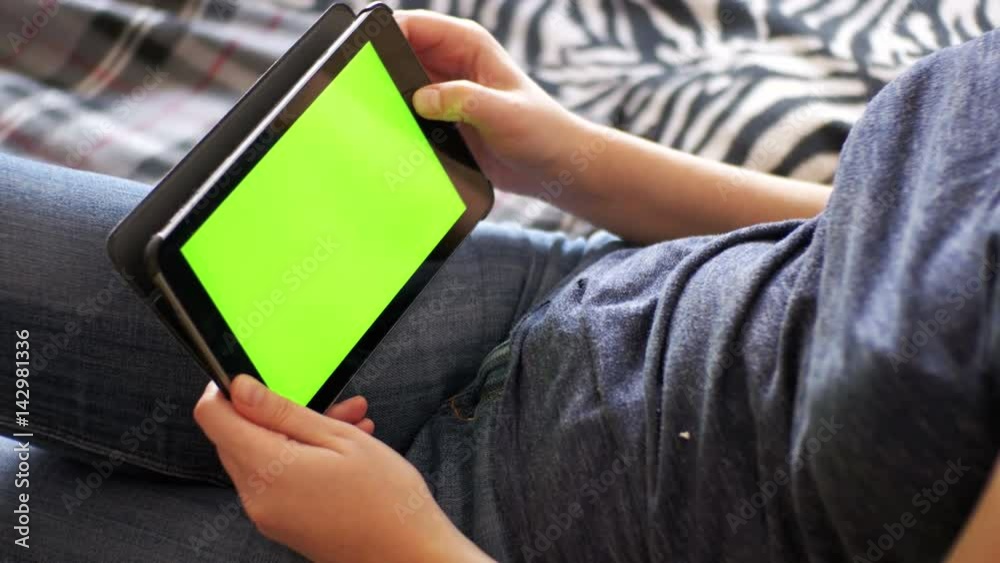 Girl Lying on Bed and using Tablet with Pre-Keyed Green Screen at Home ...