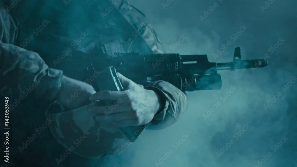 Soldier with assault rifle in hand. Loading kalashnikov magazine ...