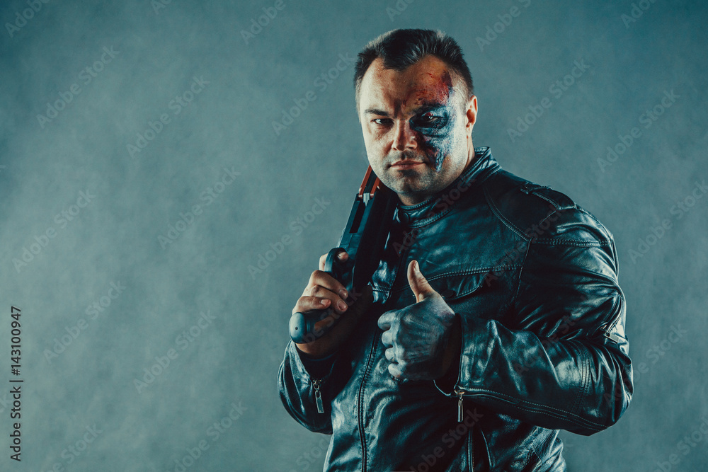 Dangerous man with scares and burns on the face is holding a shotgun ...