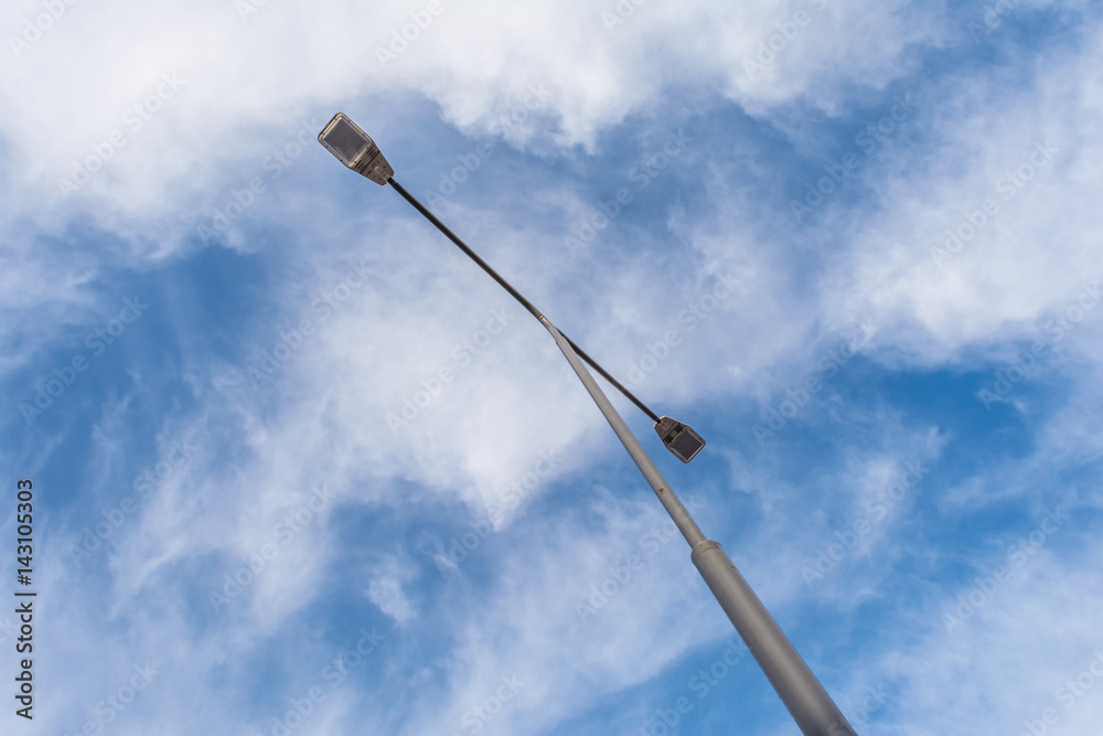 Street lamppost with two searchlights in the daytime against a ...