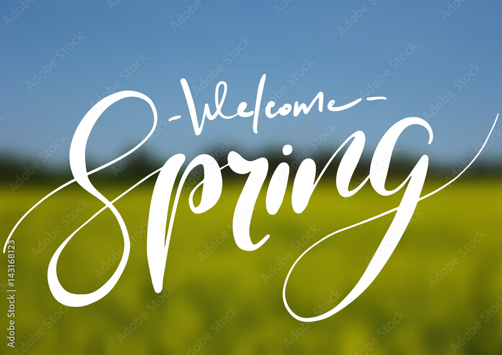 Welcome spring handwriting lettering design on blurry blossom field ...