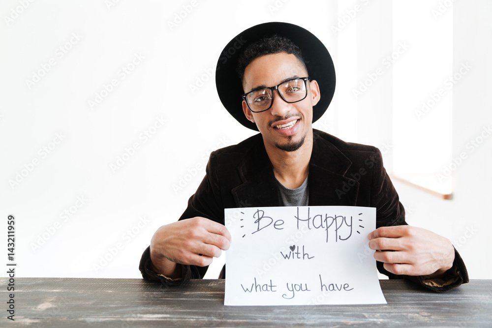 Young Smiling African man showing sheet of paper Stock Photo | Adobe Stock