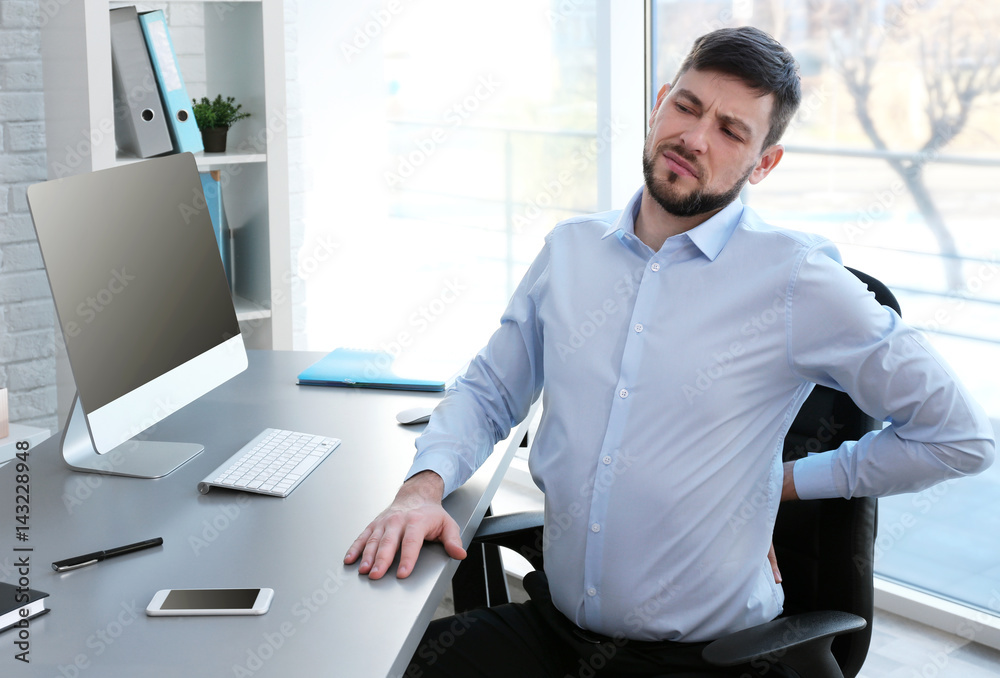 Posture concept. Man suffering from back pain while working with ...