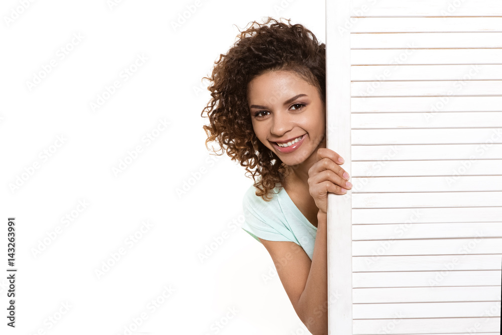 Beautiful woman looking out from behind the door Stock Photo | Adobe Stock