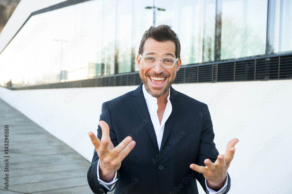 Portrait of happy businessman outdoors gesturing Stock Photo | Adobe Stock