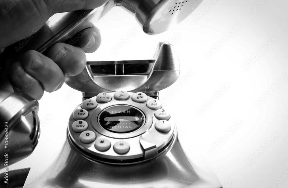 Foto de Male hand picking up phone to dial do Stock | Adobe Stock