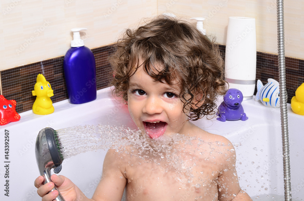 Beautiful toddler taking a bath in a bathtub with bubbles. Cute kid ...