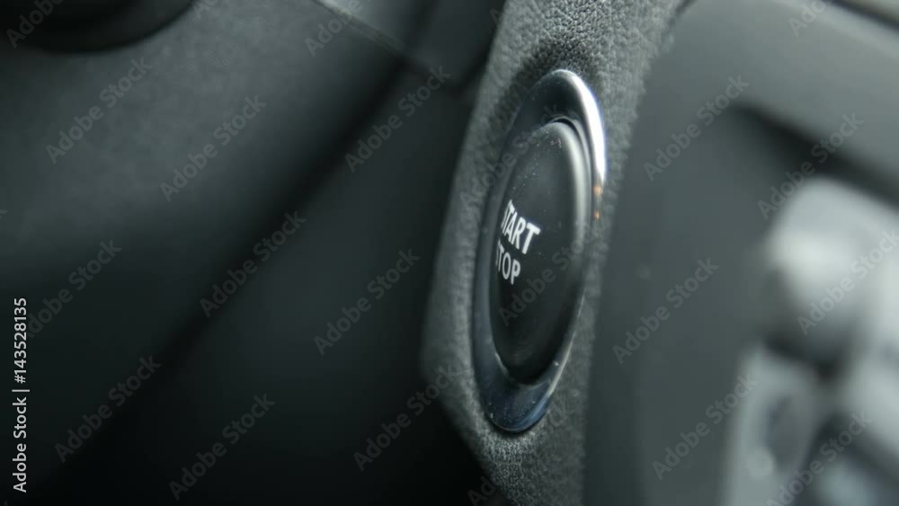 Macro footage of a female driver pressing an engine start and stop ...