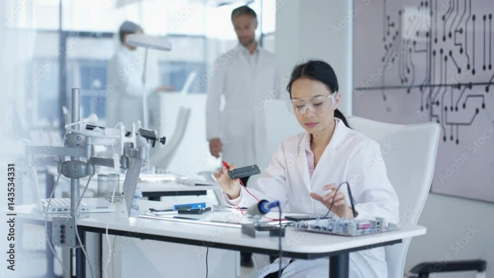 Electronics engineers working in lab building & testing electronic ...