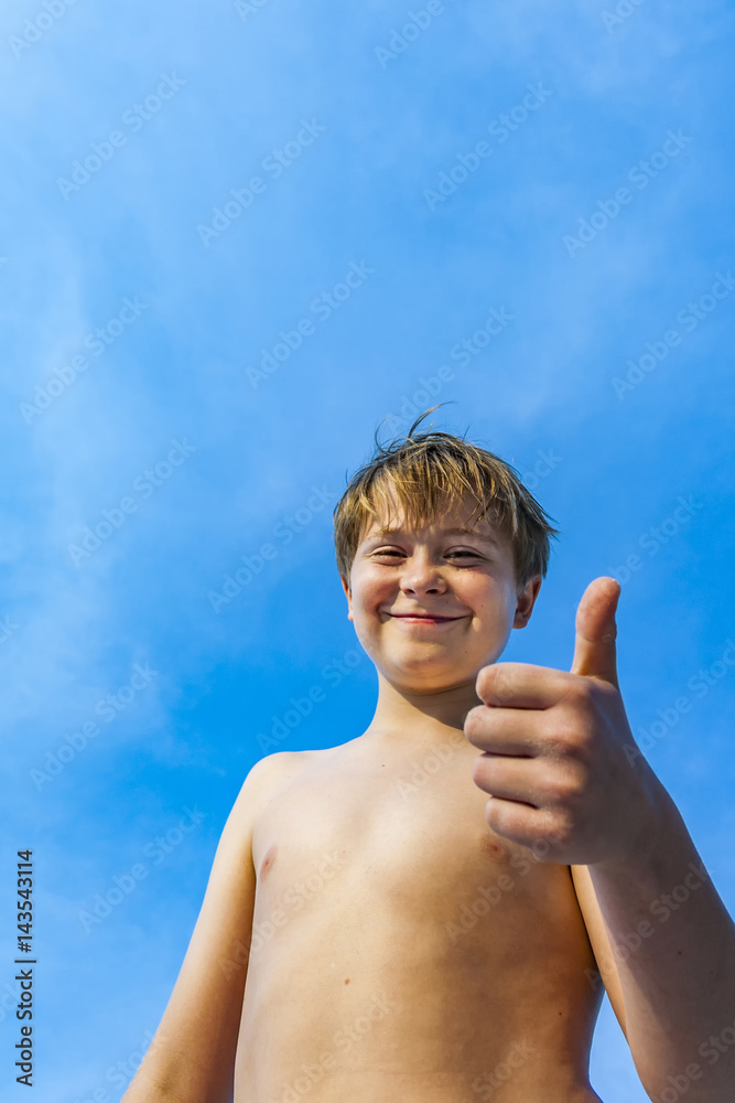 happy smiling young boy at the beach gives thumbs up sign Stock Photo | Adobe Stock