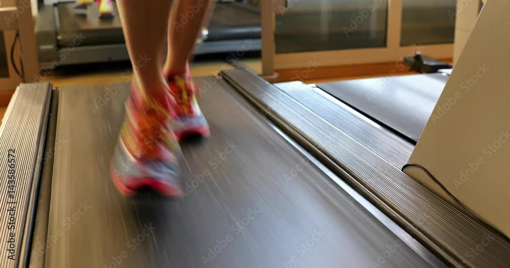 Fitness model woman running on treadmill with muscular legs indoor ...