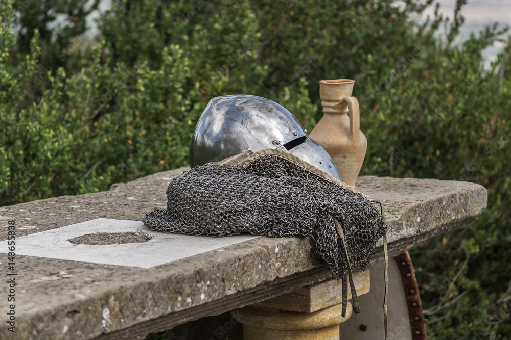 Foto de Helmet, chainmail, sword and shields on a stone table of a ...