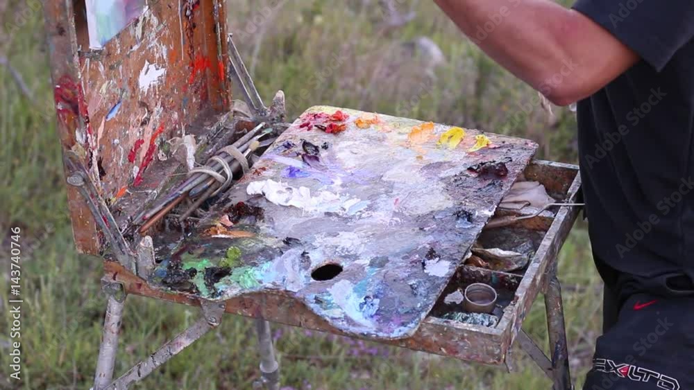 Professional Artist Paints A Picture. Artist working en plein air using ...