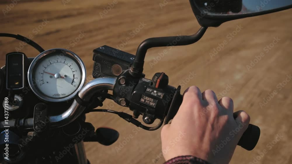 Side top view on male rider hand twists throttle grip on his classic ...