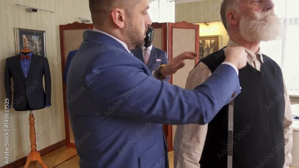 Tailor measuring client for custom made garment Stock Video | Adobe Stock