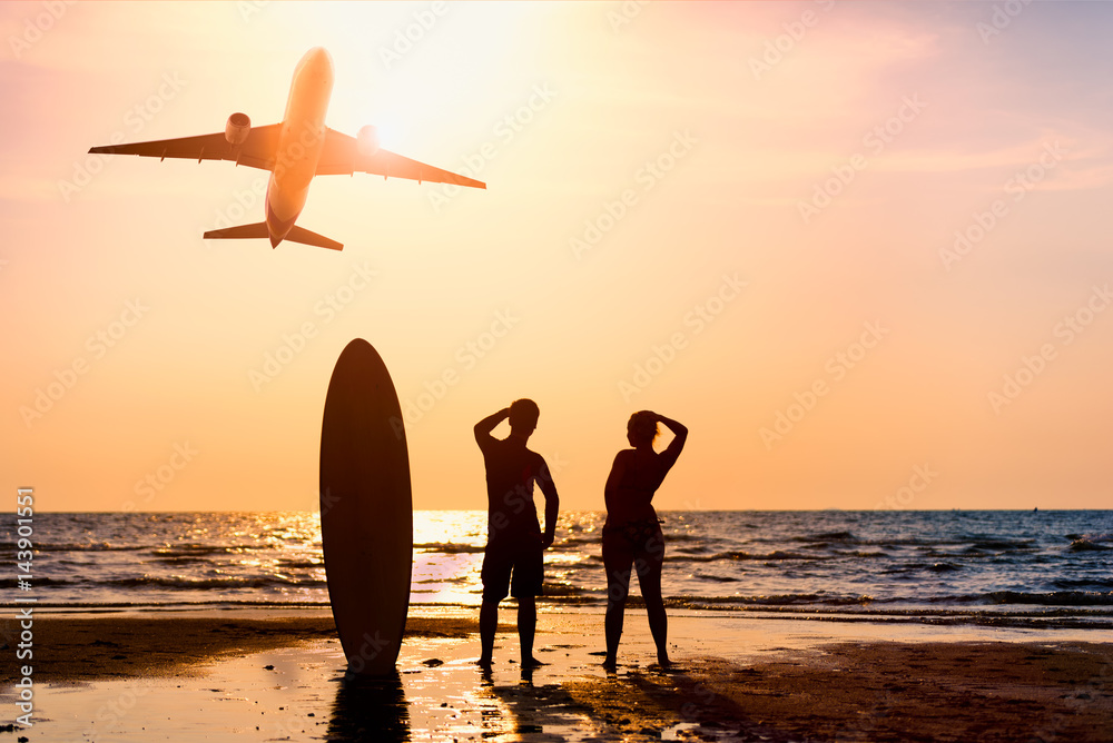 Surfer man and girlfriend standing happy on the beach looking out to ...